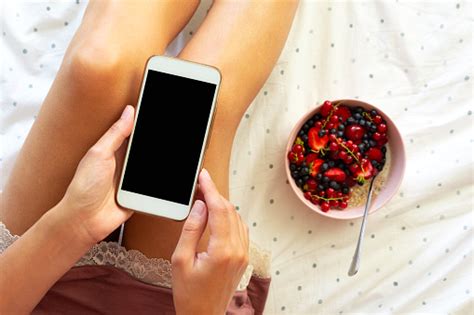 손에 스마트 폰을 들고 딸기와 오트밀 죽을 먹는 여자 건강한 식생활 개념 침대에서 건강한 여름 아침 식사 맨 위 보기 가정 생활에 대한 스톡 사진 및 기타 이미지 Istock