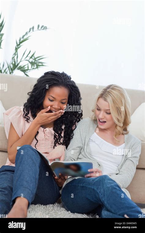Two Surprised Women Reading A Magazine Stock Photo Alamy