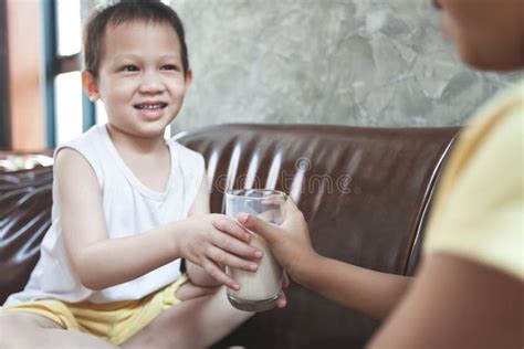 Hermana Mayor Dando Un Vaso De Leche A Su Hermano Pequeño Para Beber En