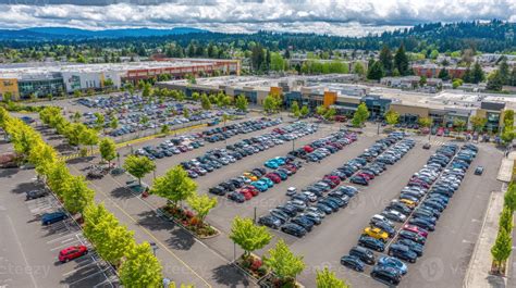 Aerial View Of A Large Outdoor Shopping Mall With Parking Lot And Urban