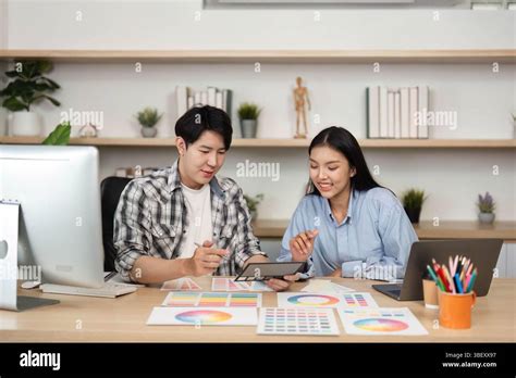 Ux And Ui Design Collaboration Young Professionals Discussing Color Palettes And Layouts In A