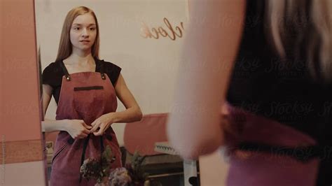 Woman Checking Uniform Before Starting Workday By Stocksy Contributor