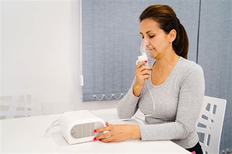 가정이나 병원 독감 천식 기관지염 바이러스 치유에서 에어로졸 흡입 의학 치료를하고 증기 흡입기 분무기를 사용하는 성인 여성의 초상화 가정 생활에 대한 스톡 사진 및 기타