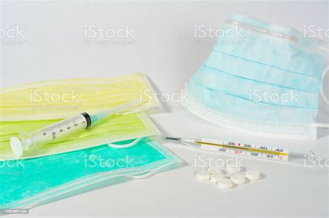온도계 의료 용 마스크 백신 주사기 및 치료사사무실의 가벼운 테이블에 알약이 있는 주사기가 닫힙시다 중국 우한 로마 코로나