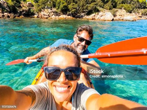 바다에서 투명한 푸른 깨끗한 물에서 카약 카누 여행 여행을 즐기는 행복한 활동적인 성인 커플 여름 방학에 남자와 여자의 행복의
