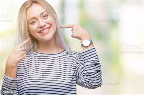 젊은 금발 여자 격리 된 배경에 보여주는 자신감과 가리키는 손가락 치아와 입 미소 건강 개념입니다 가리키기에 대한 스톡 사진 및 기타 이미지 Istock
