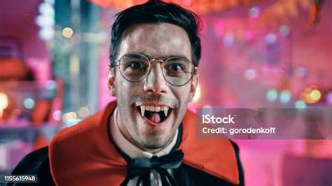 할로윈 의상 파티 수의 초상화 드라큘라 미소 웃음 그의 치명적인 피 묻은 송곳 니를 보여줍니다 배경에 무서운 물건으로 장식 된