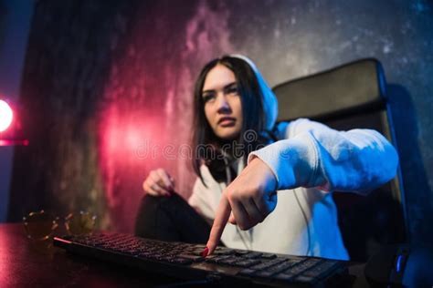 Woman In The Hood Sitting And Working At Laptop As Hacker Running