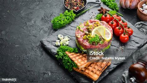 원시 달걀 노 른 자 아보카도 케이 퍼 및 양파가 들어 있는 비프 스테이크 타르트 프랑스 요리를 선보입니다 평면도 텍스트를 위한 여유 공간 고급 요리에 대한 스톡 사진 및