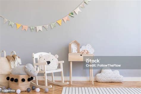 스칸디나비아 아이 룸 회색 벽 천연 바구니 어린이의 자에 테 디 베어와 디자인 장난감 다채로운 면 깃발 및 액세서리와 함께 나무 선반 귀여운 현대적인 인테리어 복사 공간
