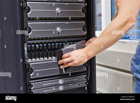 It Engineer Consultant Working In A Data Center Holding A Disk