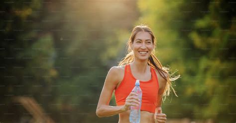 긴 머리를 가진 젊은 미소 긍정적 인 매력적인 스포츠맨은 아침에 물 한 병을 들고 공공 공원에서 달리고 있습니다 사진 Unsplash의 아침 달리기 이미지