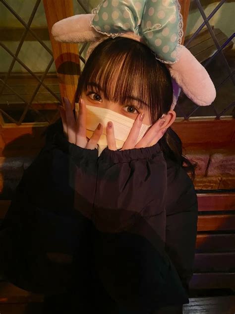 A Young Woman Wearing Bunny Ears And Holding Her Face Up To The Camera