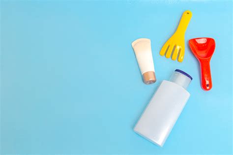 선스크린 크림 Spf 로션 수영장의 푸른 물 표면에 다채로운 물 장난감태양에서 아이 피부를 치료 하는 최고 보기 컨셉 자외선 보호 제품 여름 어린이 화장품 0명에 대한 스톡