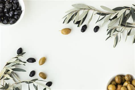 흰색 바탕에 올리브 오일과 나뭇잎 병 옆에 흰색 그릇에 녹색과 검은 색 올리브 냉간 압착 오일 한 병 전통적인 그리스와 이탈리아 음식 플랫 레이 0명에 대한 스톡 사진 및