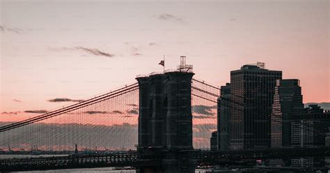 고층 건물 옆의 강을 가로지르는 큰 다리 사진 Unsplash의 Nyc 스카이 이미지