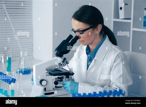 In A Modern Lab A Skilled Female Scientist Analyzes Biological And Chemical Samples Under A