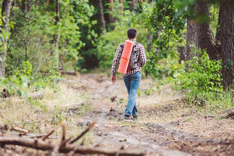 개념 아슬 아슬한 여행과 모험 백 뷰 하이킹 용감한 백인 남자 배낭 시골 길을 따라 숲으로 산책 테마 관광 및 야외 활동 배낭 여행자는 숲을 통해 간다 관광에 대한 스톡
