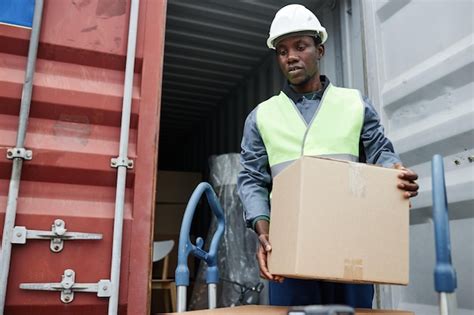 Premium Photo Waist Up Portrait Of African American Man Unloading Boxes From Container At