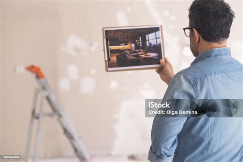 안경을 쓴 남자가 방에 서 있는 로프트 스타일의 인테리어 디자인으로 그림을 보고 있다 가정의 방에 대한 스톡 사진 및 기타 이미지 가정의 방 개선 건설 현장 Istock
