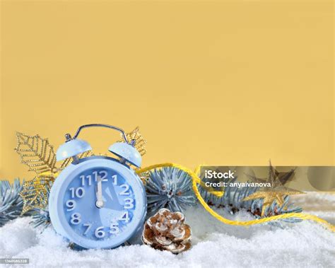 황금 노란색 배경에 크리스마스 장식 민트 블루 알람 시계 햇빛 눈 전나무 나뭇 가지 그림자가 있는 햇빛 Xmas 크리에이티브 인사말 카드 디자인 복사 공간 12월에 대한