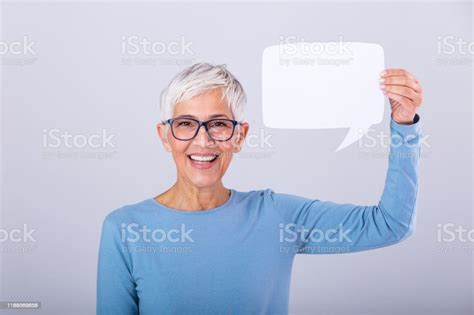 회색 배경 위에 고립 된 빈 연설 거품을 보여주는 흥분 성숙한 회색 머리 여자의 초상화 연설 거품 배너를 들고 시니어 여성 대화 풍선 문자 기호에 대한 스톡 사진 및 기타