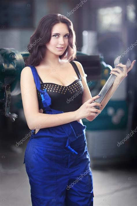 Nice Sexy Woman Mechanic Holding Wrench Girl Weared In Blue Work Overalls Standing Over The