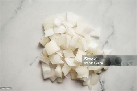 하얀 대리석 배경에 중간 깍둑썰기한 양파 사진은 양파를 중간 입방체로 얇게 썰어 얇게 썰고 깍둑썰기한 양파가 어떻게 생겼는지