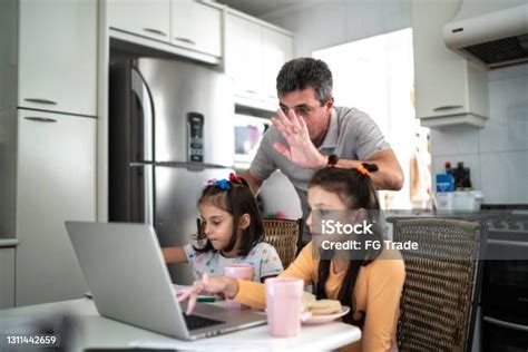 집에서 딸의 가상 수업 중에 노트북에 손을 흔들고 있는 아버지 45 49세에 대한 스톡 사진 및 기타 이미지 45 49세 8 9 살 Brand Name Online