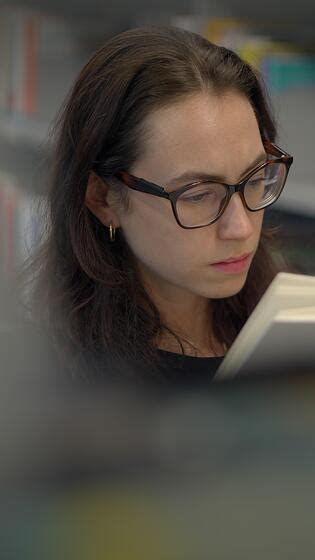 A Focused Reader Within A Modern Library Setting That Encourages