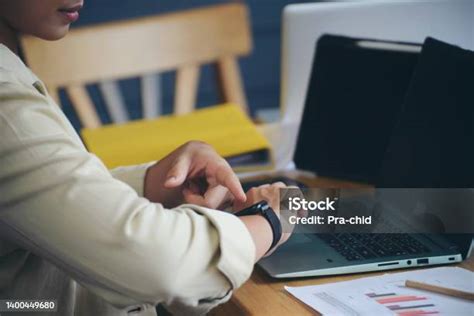 시간을 확인하고 홈 오피스에서 스마트 손목 시계를보고있는 사업가 아시아 여자는 일할 시계를보고 노트북 연간 및 요약 보고서가있는 책상 약속 모임 개념에 대한 시간 초과 가정