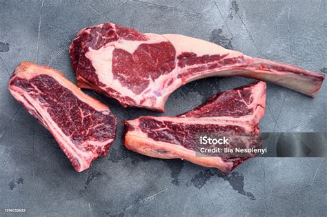 회색 돌 배경에 고기 건조 숙성 쇠고기 토마호크 T 뼈 또는 포터 하우스와 클럽 스테이크의 다양한 컷 상단 보기 플랫 누워 0