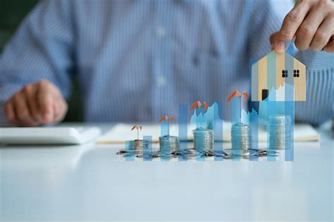 집과 프레스 계산기를 들고 재무 보고서를 계산하는 사업가 위기에 처한 집에서의 재정 계획 동전과 그래프 더미가있는 주택 예산 계획 1 달러 지폐 미국 지폐 통화에 대한 스톡