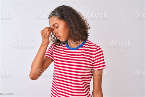 고립 된 흰색 배경 에 서 빨간색 줄무늬 티셔츠를 입고 젊은 브라질 여성은 피로와 두통을 느끼는 코와 눈을 문질러 피곤 스트레스와 좌절 개념 T 셔츠에 대한 스톡 사진 및