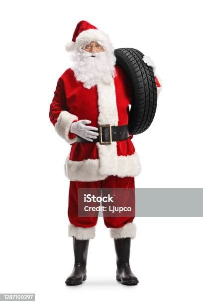 흰색 배경에 고립 된 그의 어깨에 자동차 타이어를 들고 산타 클로스의 전체 길이 초상화 산타 클로스에 대한 스톡 사진 및 기타 이미지 산타 클로스 타이어 크리스마스