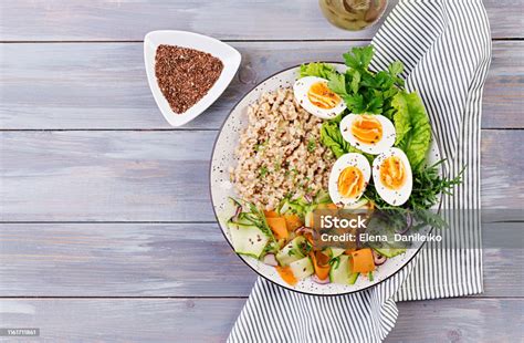 오트밀 호박 양상추 당근 삶은 달걀을 곁들인 조식 그릇 신선한 샐러드 건강한 음식 채식 불상 그릇입니다 맨 위 보기 오트밀에