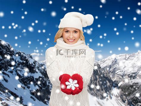 穿着冬装、带着雪花微笑的女人高清摄影大图 千库网