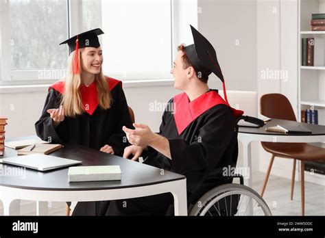 Male Graduate In Wheelchair Chatting With Classmate At University Stock