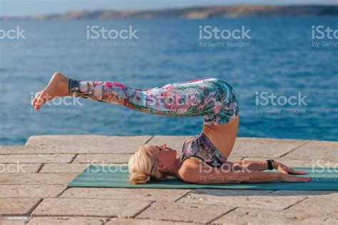 쟁기 자세로 매트에 스트레칭을 하는 중년 여성 바닷가 부두 45 49세에 대한 스톡 사진 및 기타 이미지 45 49세 건강한 생활방식 결심 Istock