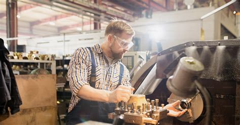 작업복을 쓴 젊은 정비사와 보호 안경을 착용하고 거대한 산업 기계 옆에 서서 작업을 준비하고 있습니다 사진 Unsplash의 기술자 이미지