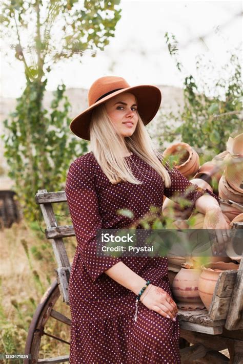 목조 시골 수레로드에서 도자기 주전자 근처 모자와 드레스를 입은 젊은 여성 느린 생활 라이프 스타일 개념 카파도키아 여행 모험 30 34세에 대한 스톡 사진 및 기타 이미지
