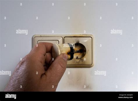 Hand Removing Plug From An Over Heated Socket Stock Photo Alamy