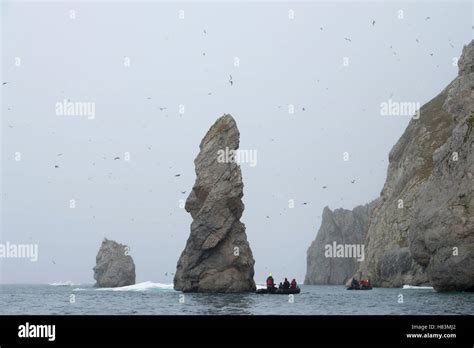 People In Zodiac Boat Investigating Sea Stack Wrangel Island Russia