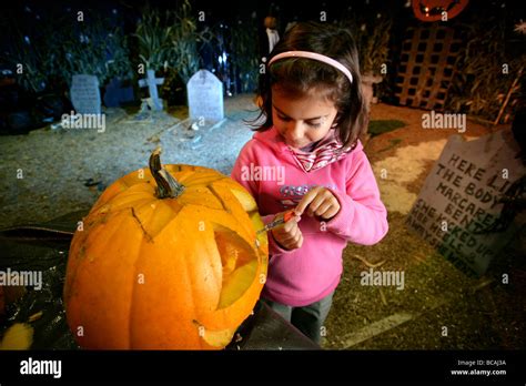 Girl Carves A Face Into A Pumpkin For Halloween Stock Photo Alamy
