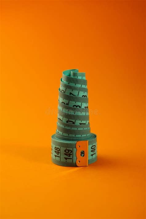 on a bright orange background a blue sewing centimeter and a juicy