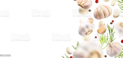 밝은 흰색 배경에 빨간색과 검은색 후추와 허브가 있는 플라잉 마늘 요리를위한 매운 향긋한 조미료 음식 디자인 광고 메뉴 및 레시피를 위한 창의적인 음식 개념 복사 공간