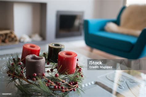 녹색과 빨간색 색상의 크리스마스 장식 화려한 촛불과 강림절 크라운 난로가 있는 현대적인 거실 마드리드 스페인 유리 재료에 대한