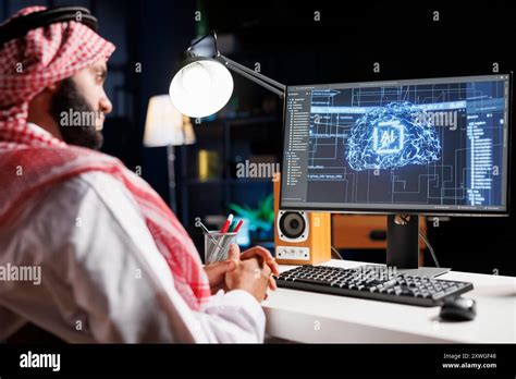 Detailed Image Of Middle Eastern Developer In Front Of Desktop Pc Monitoring A Complex Network