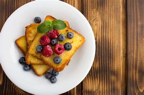 갈색 나무 배경의 흰색 접시에 베리와 꿀이있는 프렌치 토스트 맨 위 보기입니다 공간을 복사합니다 0명에 대한 스톡 사진 및 기타 이미지 Istock