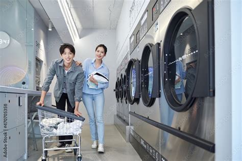 셀프 세탁실을 배경으로 대학생 커플 또는 신혼부부가 함께 또는 혼자 세탁기 또는 건조기 작동과 빨래 정리하는 모습 아시아 한국 남녀 모델 Stock 写真 Adobe Stock